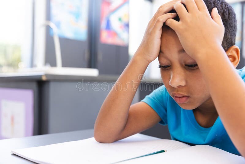 Biracial Boy Studying Hard in the Classroom at School, with Copy Space ...