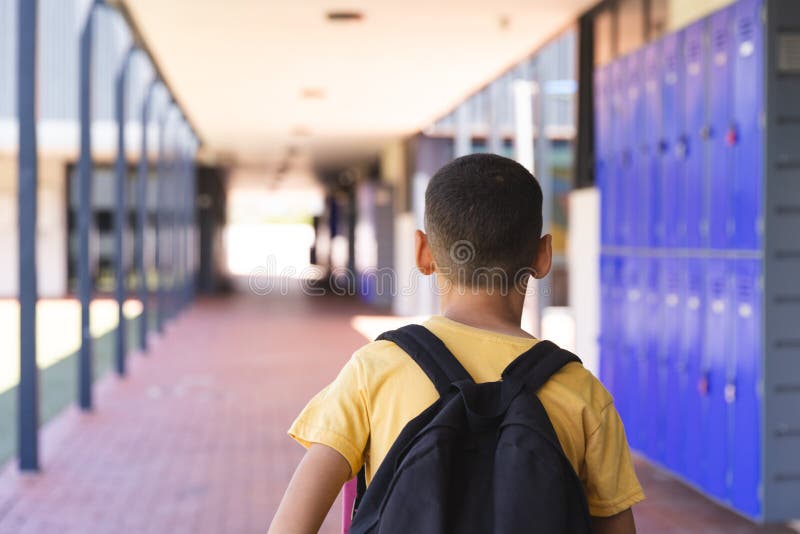 Biracial Boy Walks Down a School Hallway, with Copy Space Stock Image ...
