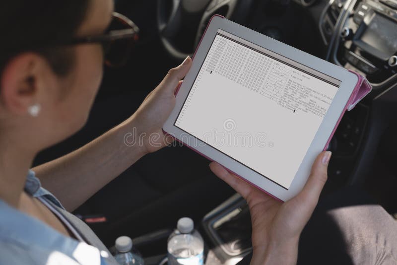 Biracial Female Programmer Sitting in Car, Using Tablet with Coding on ...