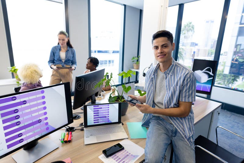 Biracial Man in Modern Office Using Smartphone, Collaborating with ...