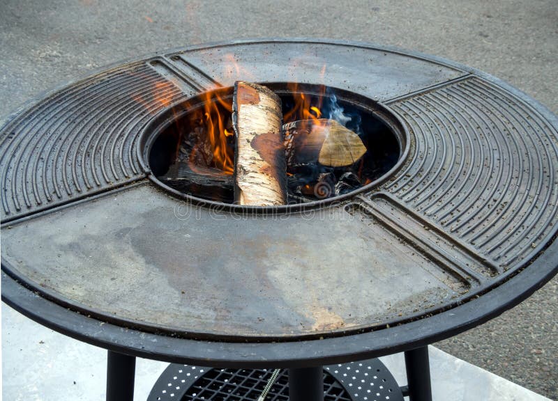 Birch Firewood Burns in the Center of a Round Metal Barbecue Table ...
