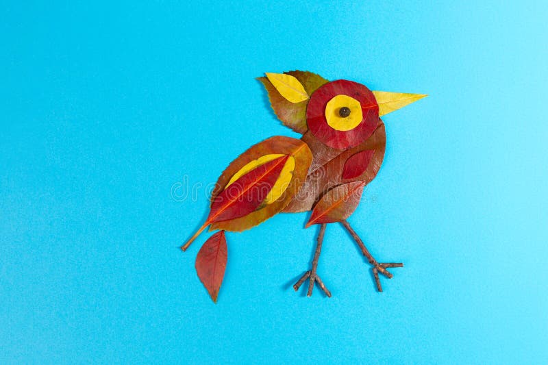 A Bird Made from Various Colorful Autumn Dry Leaves Against a Solid ...