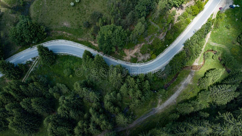Bird S-eye View of a Winding Hill Road Passing through a Green Terrain ...