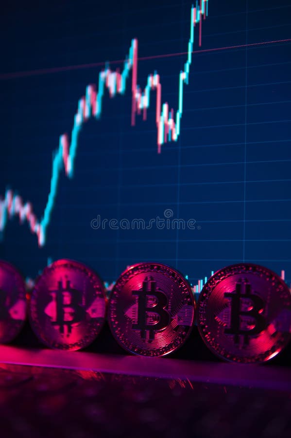 Bitcoin Coins are Standing on Laptop in Neon Light with a Chart on a ...
