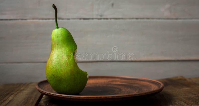 A Bite Pear on a Plate on Wooden Background Stock Photo - Image of food ...