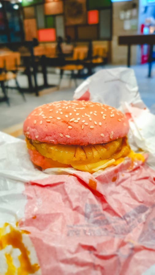 Bite Taken from a Delicious Cheeseburger. Pink Burger with Toppings ...