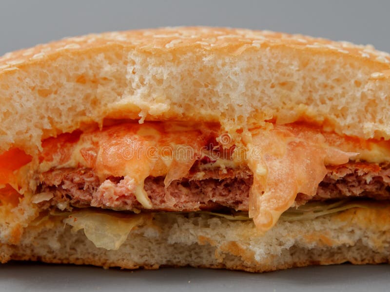 Bitten Big Burger with Cutlet Cheese and Tomato on a Gray Background ...