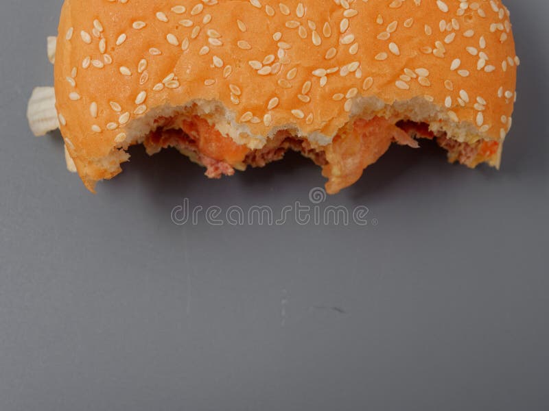 Bitten Big Burger with Cutlet Cheese and Tomato on a Gray Background ...