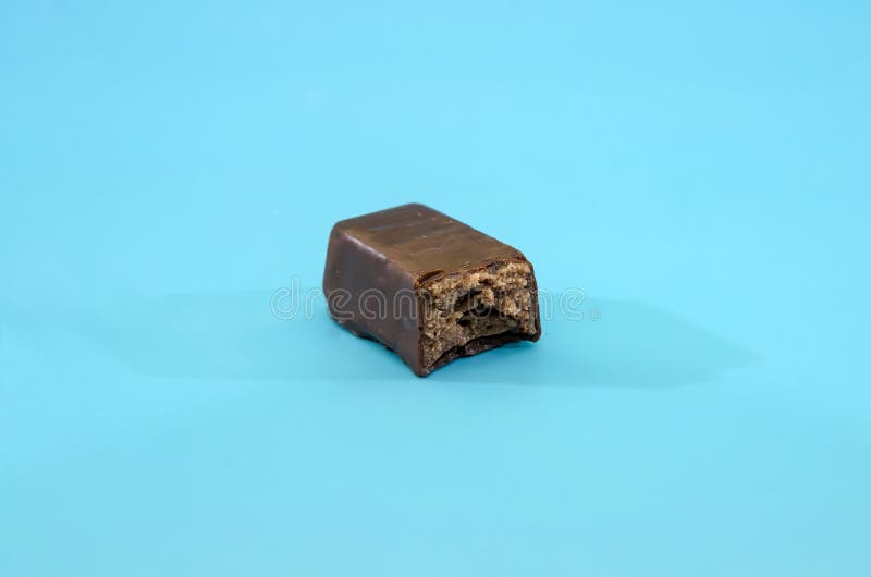 Bitten Chocolate Candy Isolated on a Blue Background.a Piece of Candy ...