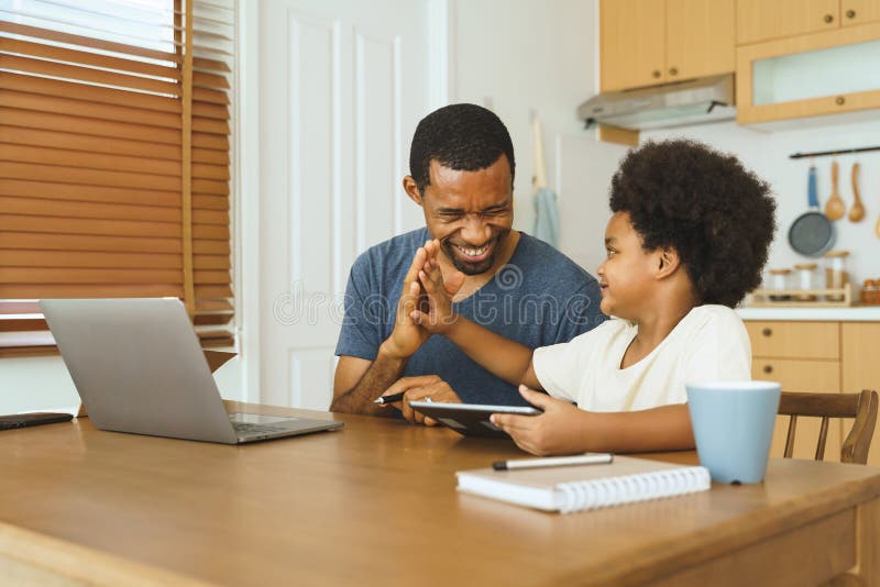 Black African American Father and Son High Five at Kitchen Table after ...