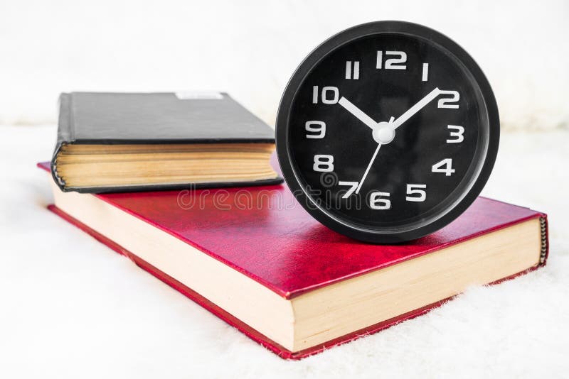 Black Alarm Clock and Book Stacked on Table Stock Photo - Image of ...