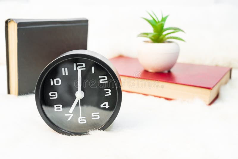 Black Alarm Clock and Book Stacked on Table Stock Photo - Image of ...