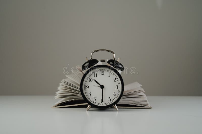 Black Alarm Clock and Open Book Stock Image - Image of literary ...