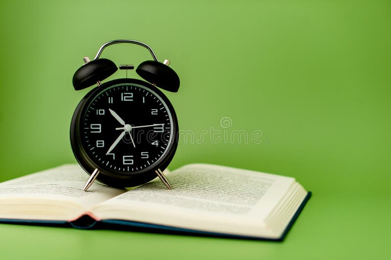 Black Alarm Clock Put on an Open Book, Reading Ideas and Reading Time ...