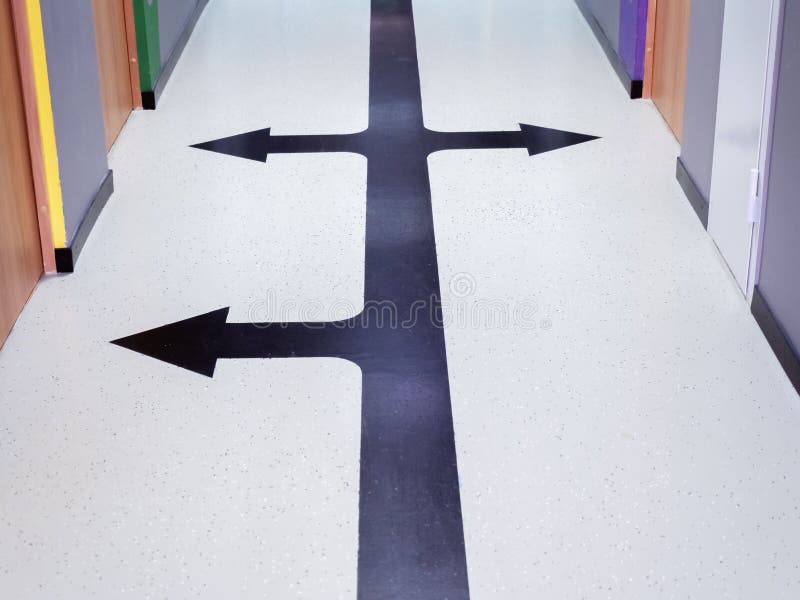 A Black Arrow Drawn Painted on the Floor in the Hallway Points in ...