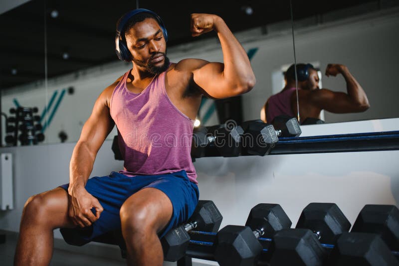 Black Athlete Flexing Muscles, Demonstrating Strong Biceps in Gym Stock ...