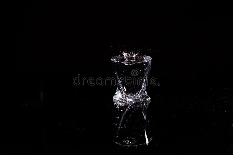 Black Background is a Glass in Which a Drop of Water Falls. Splashing ...