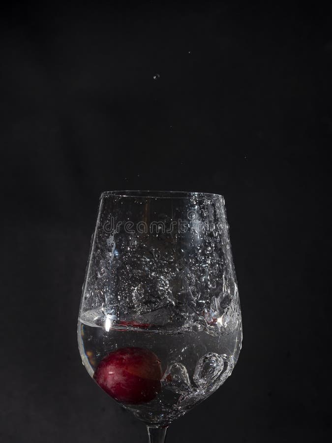 Cup with Water Falling from a Strawberry and Splashing Out of the Cup ...