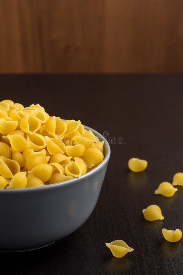 Black Background with Italian Raw Conchiglie Paste Shells in Bowl with ...