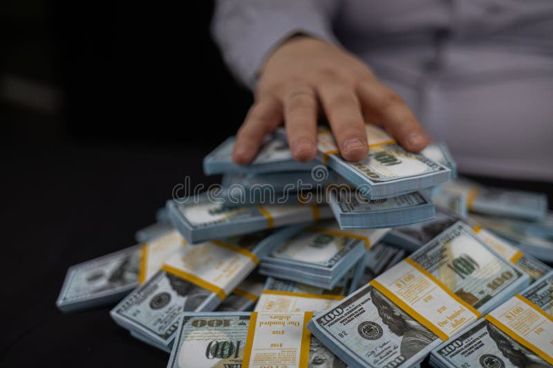 On a Black Background, a Man Put His Hand on a Pile of Money. a Bunch ...