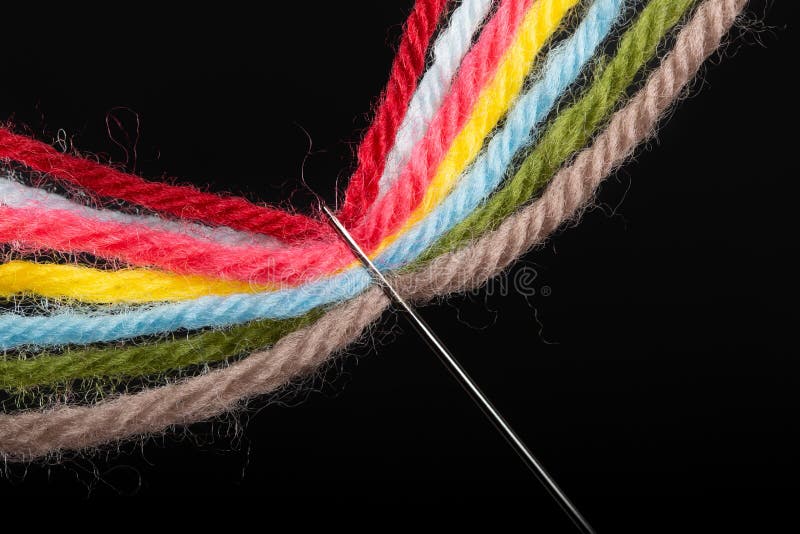 On a Black Background, Several Bright Multicolored Woolen Threads are ...