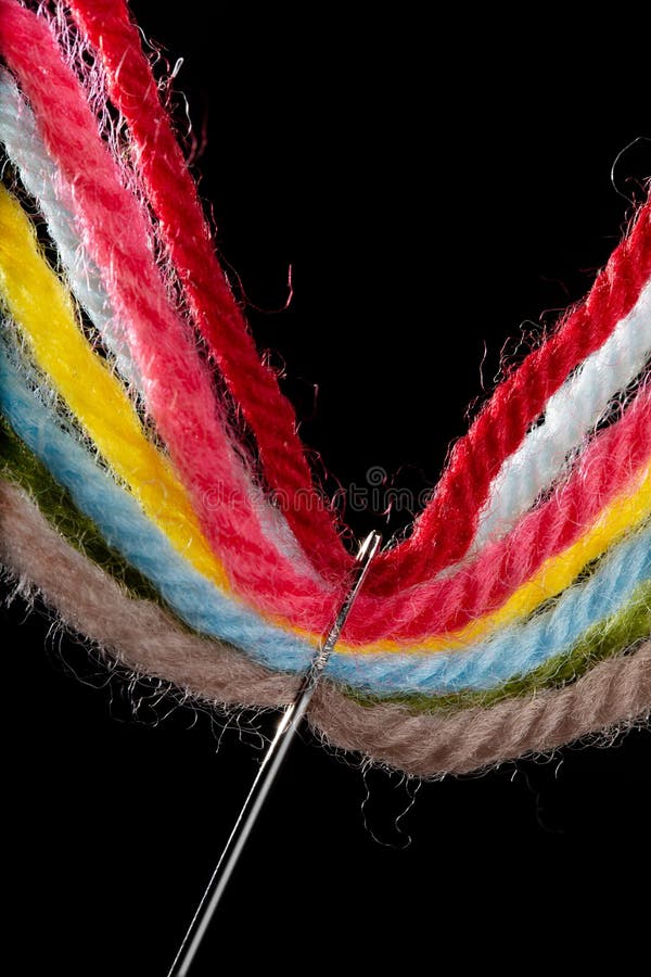 On a Black Background, Several Bright Multicolored Woolen Threads are ...