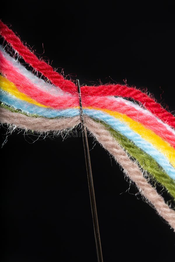 On a Black Background, Several Bright Multicolored Woolen Threads are ...