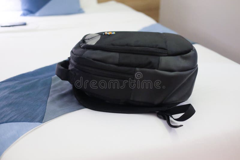 Black backpack bag on bed stock image. Image of activity - 130975883