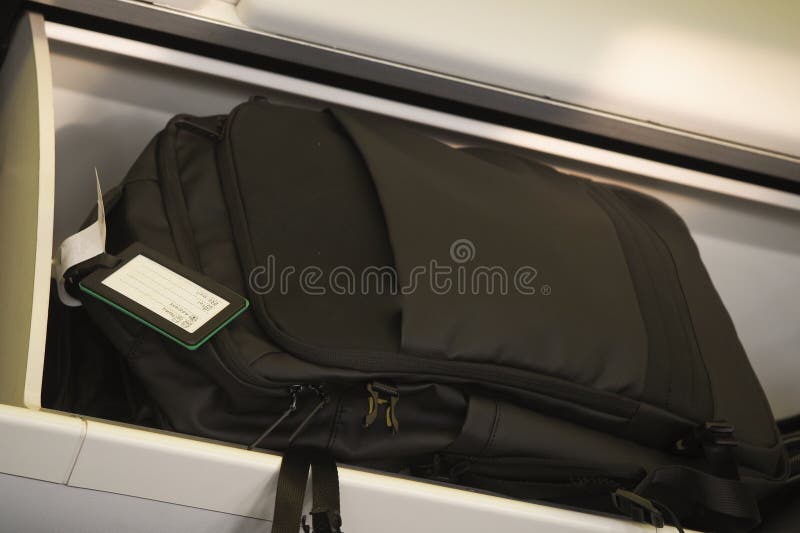 A Black Backpack Has Been Conveniently Stored in the Overhead Cabin ...