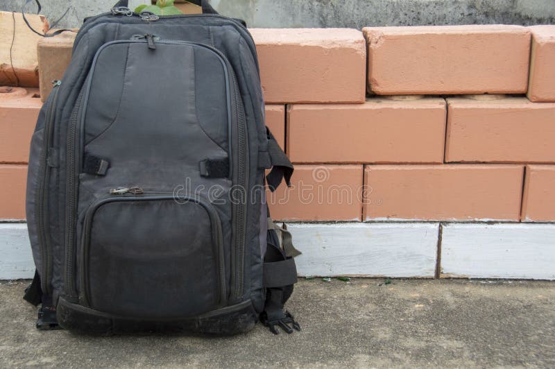 A Black Backpack Leans Against a Brick Wall Stock Photo - Image of ...