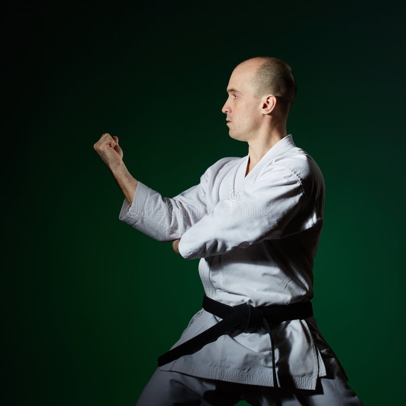 With a Black Belt, the Athlete Does Formal Karate Exercises on a Dark ...