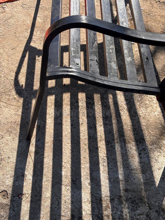 A Black Bench Casts a Shadow on the Ground Stock Image - Image of casts ...
