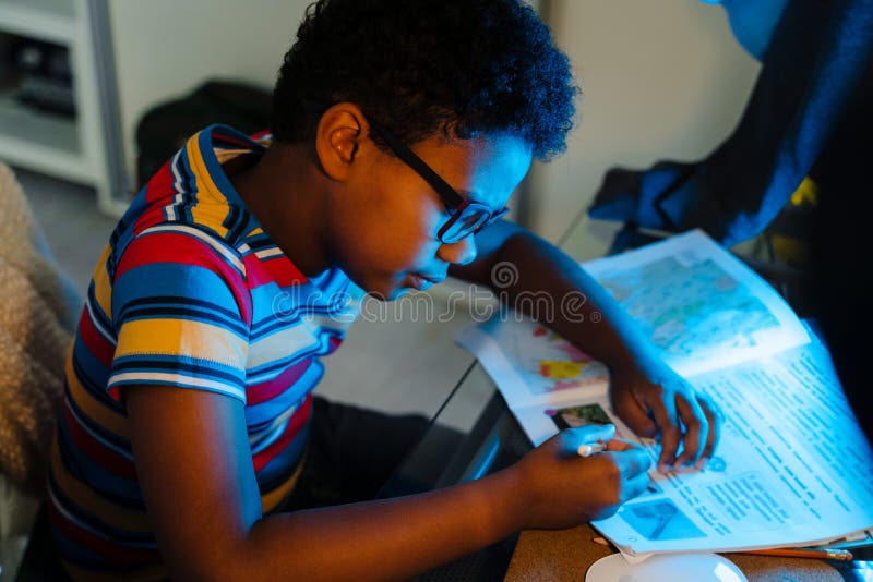 Black Boy in Eyeglasses Doing Homework while Sitting at Table Stock ...