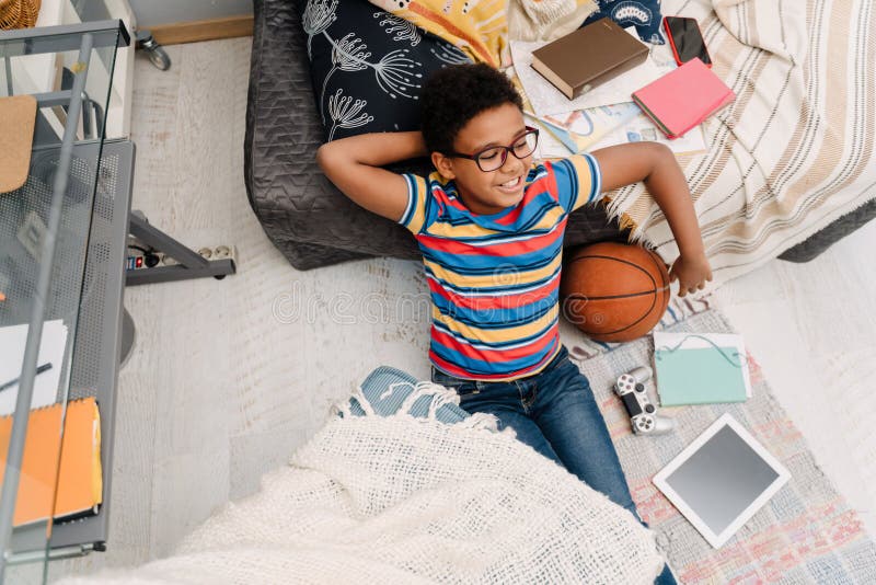 Black Boy in Eyeglasses Laughing while Sitting on Floor Stock Photo ...