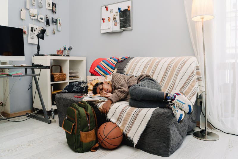 Black Boy Sleeping while Doing Homework on Sofa at Home Stock Photo ...