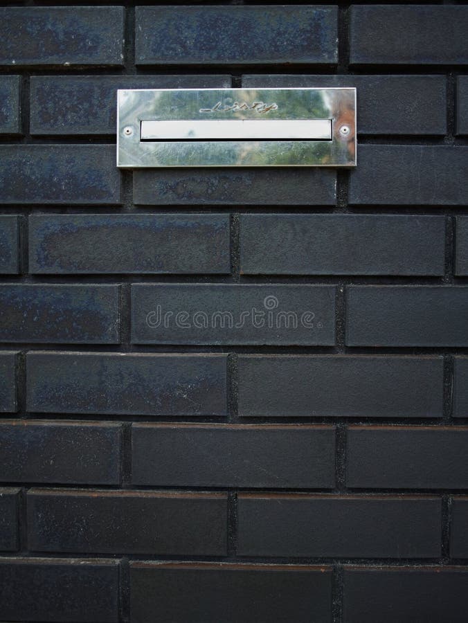 A Black Brick Wall with a Silver Mailbox on it. Black Brick Wall with ...