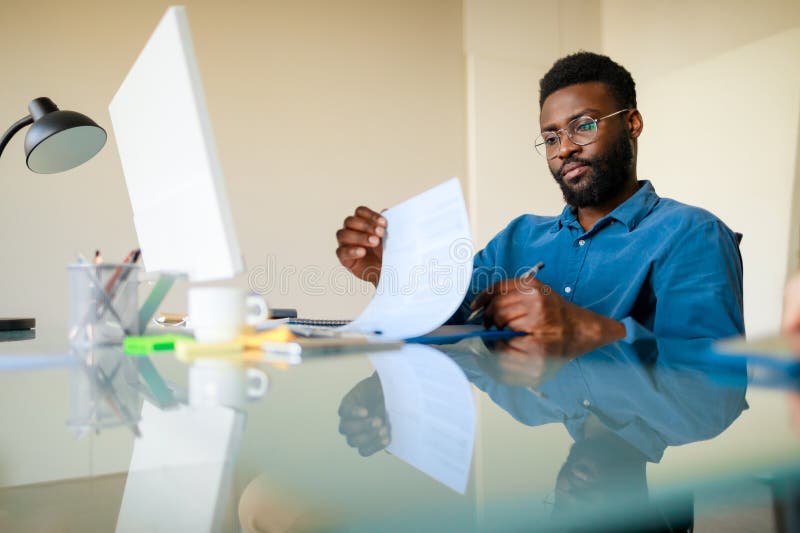 Black Businessman Working in Office with Documents and Computer, Doing ...