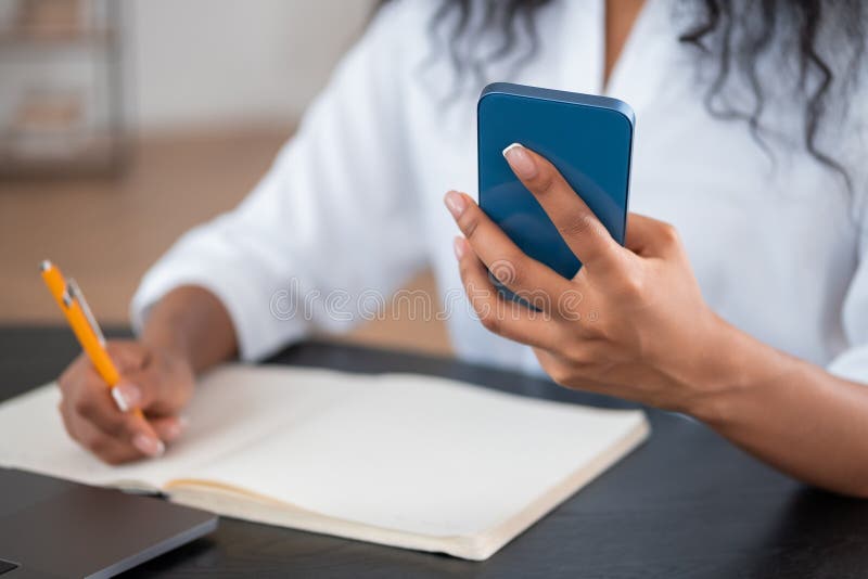 Black Businesswoman with Smartphone in Hand, Taking Notes Stock Photo ...