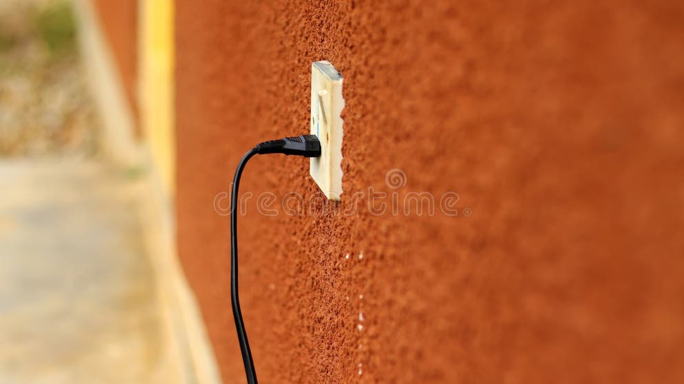 Black Cable Plugged into a Wall Socket Outside. Stock Photo - Image of ...