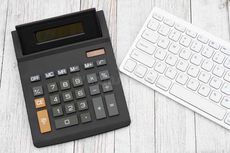 A Black Calculator with Computer Keyboard on Wood Desk Stock Image ...