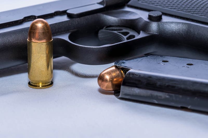 A Black 45 Caliber Pistol a Loaded Magazine Next it and an Extra Bullet ...