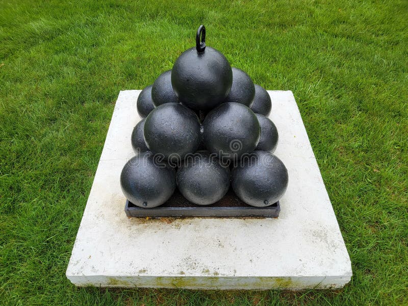 Black Cannonballs in Pyramid Stack on Cement on Grass Stock Image ...