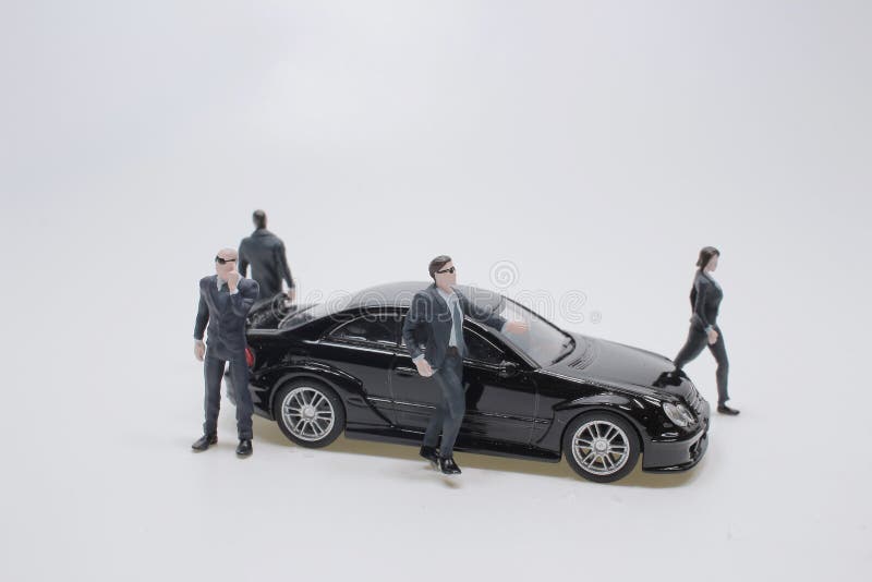 A Black Car with the Team of Mini Security Guard Stock Image - Image of ...