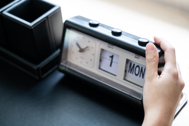 Black Clock in Hand on Work Table at Home. Show Date 1 Monday Stock ...