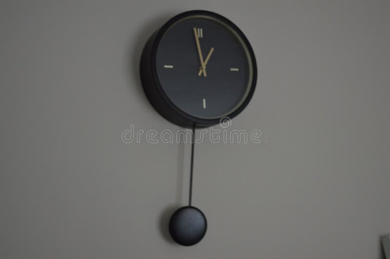 Black Monochrome Wall Clock with Pendulum on Wall Stock Image - Image ...