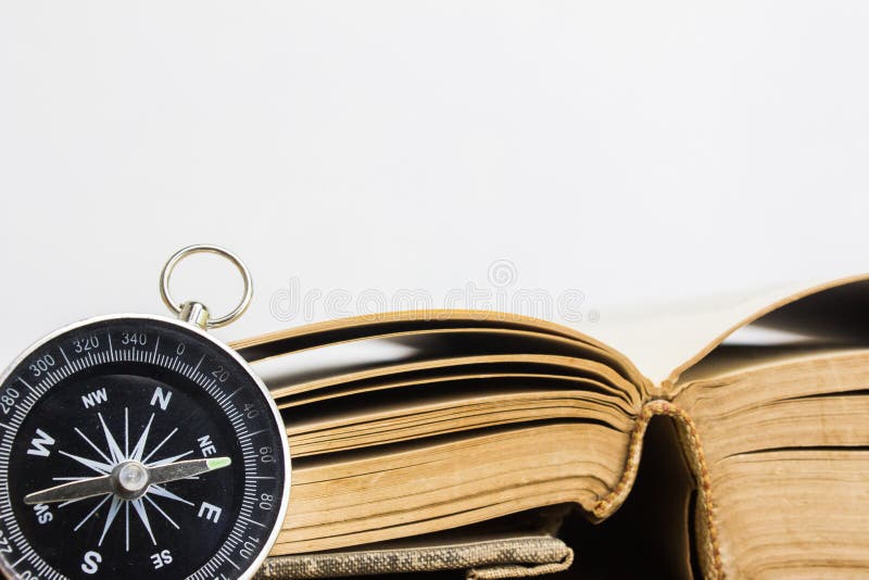 A Black Compass with Book on a Wooden Table Over the Light Wall. Stock ...