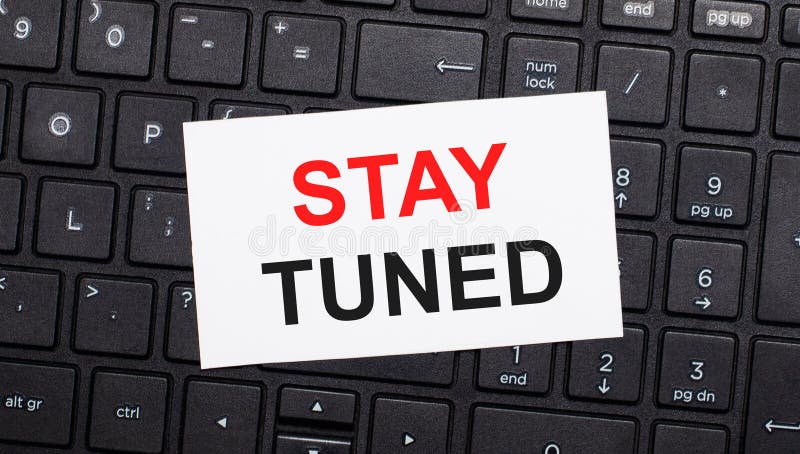 On a Black Computer Keyboard There is a White Card with the Text STAY ...