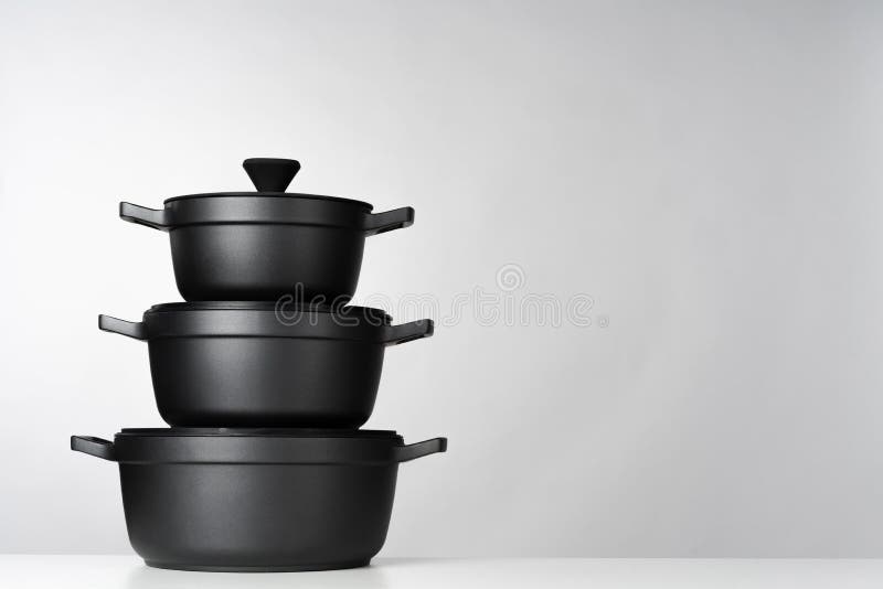 Black Cooking Pots on Grey Background Front View Stock Photo - Image of ...