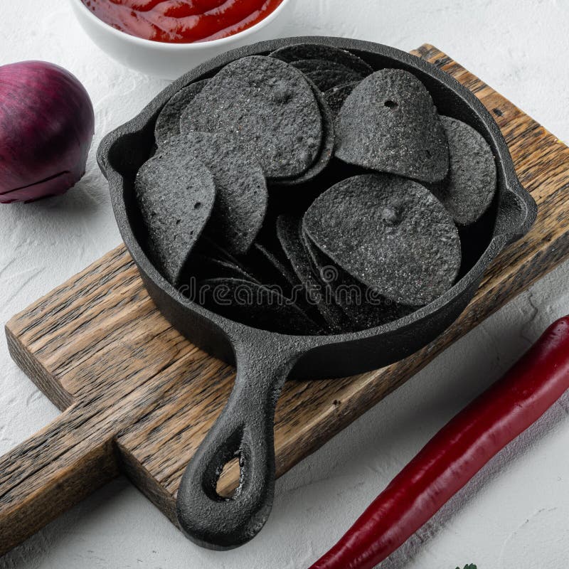 Black Crispy Potato Chips, in Cast Iron Frying Pan, on White Stone ...