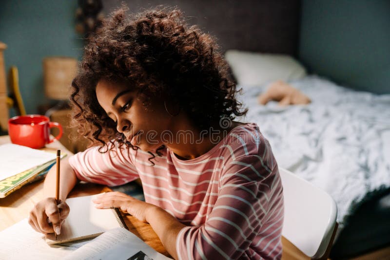 Black Curly Girl Doing Homework while Sitting at Table Stock Image ...